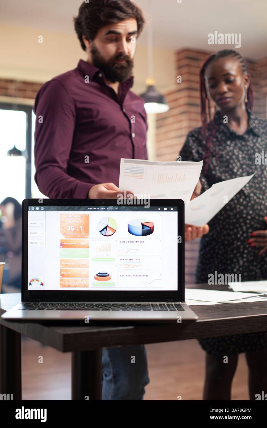 Pregnant lady and male colleague prepare market strategy as digital device shows data charts for ...