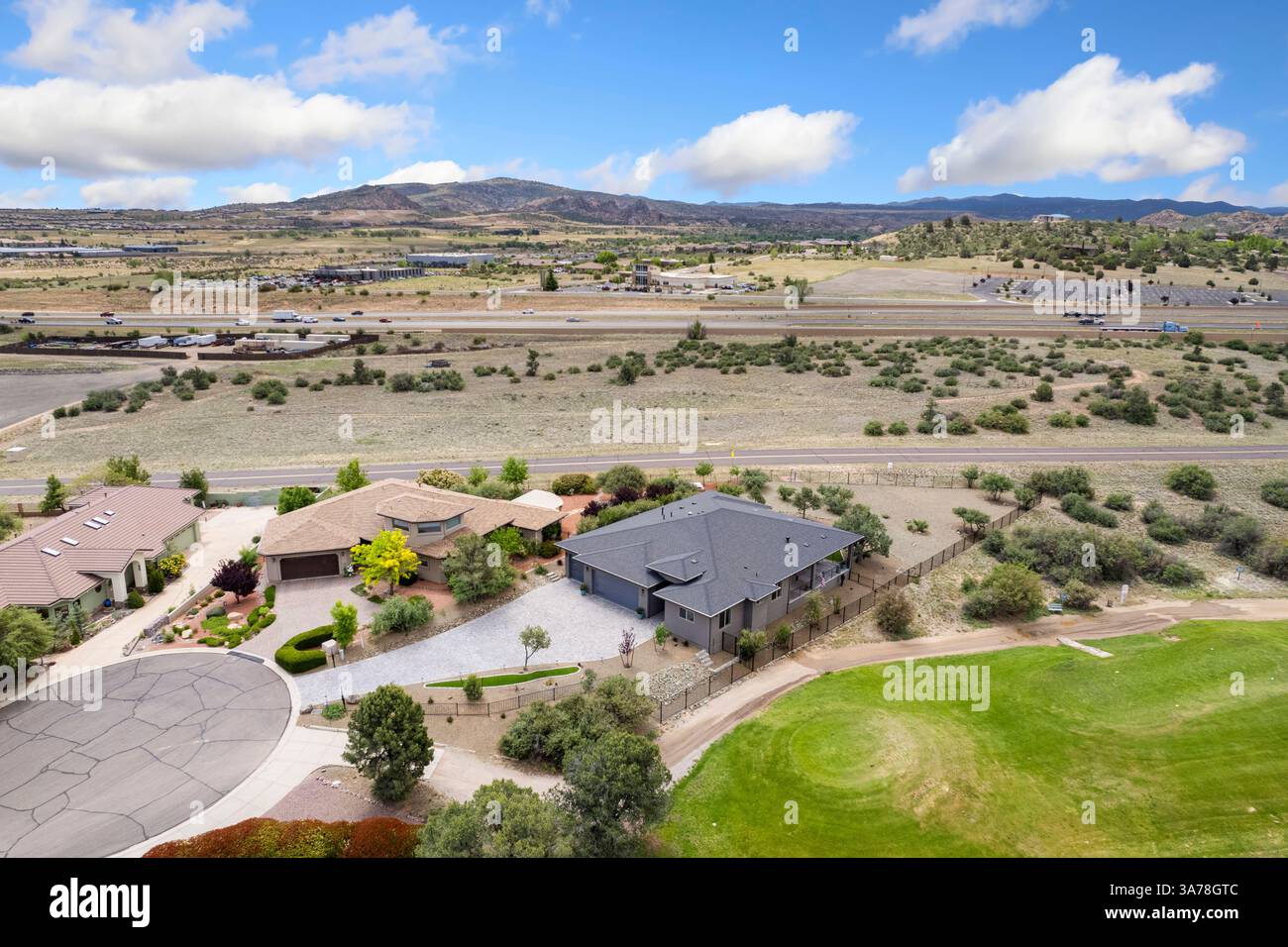 Aerial view of a house, golf course, and mountains behind Stock Photo ...
