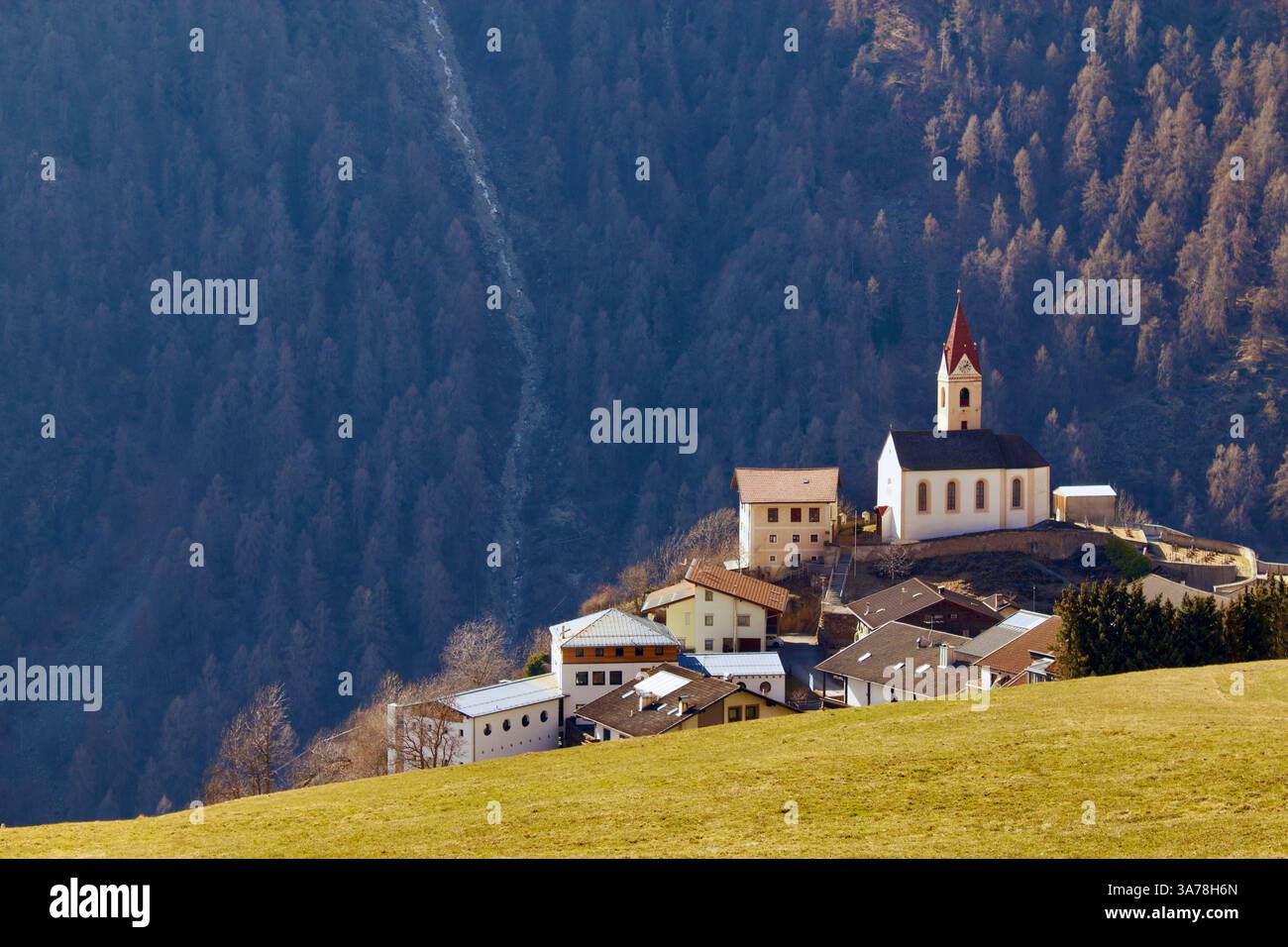 Alpine Village with Church Tower Nestled Below Forested Mountainside ...
