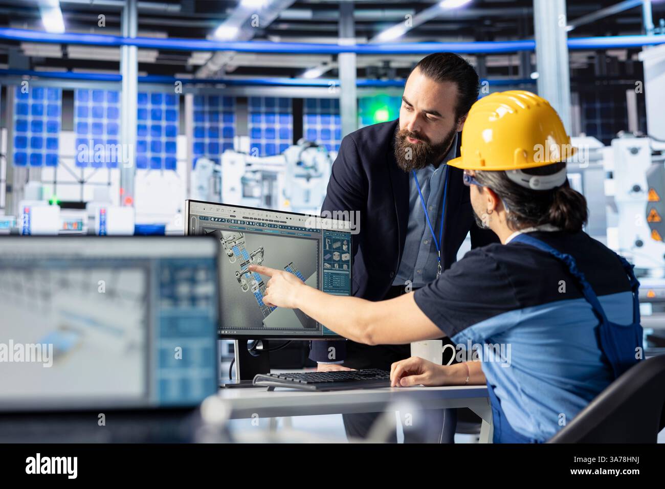 Photovoltaics factory engineer pointing to screen, showing manager ways to optimize production ...