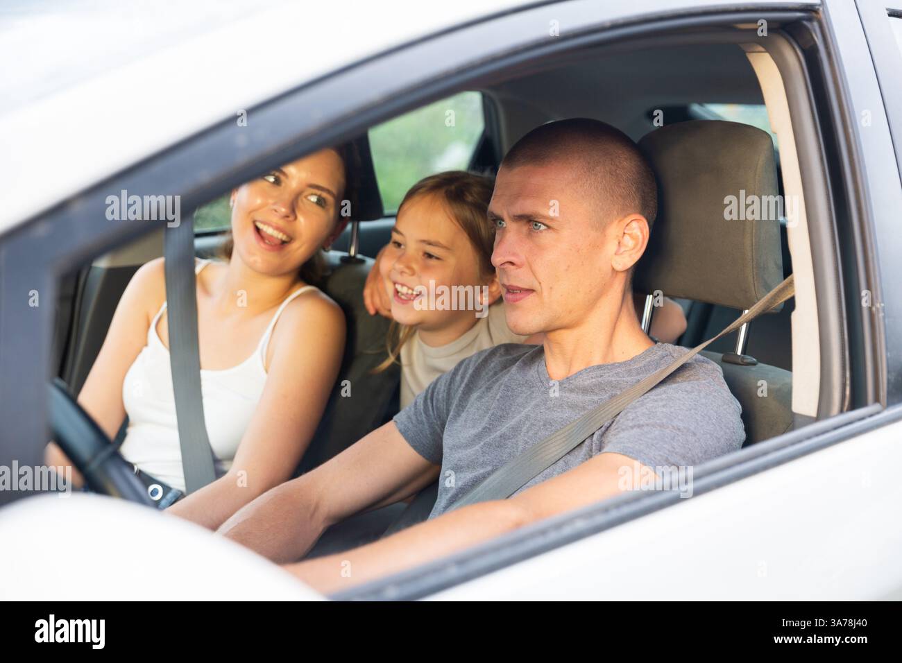 Positive family of three driving in the car Stock Photo - Alamy