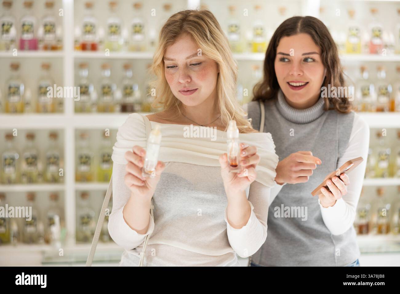 Girl offers her friend to check quality of perfume by scanning QR code ...