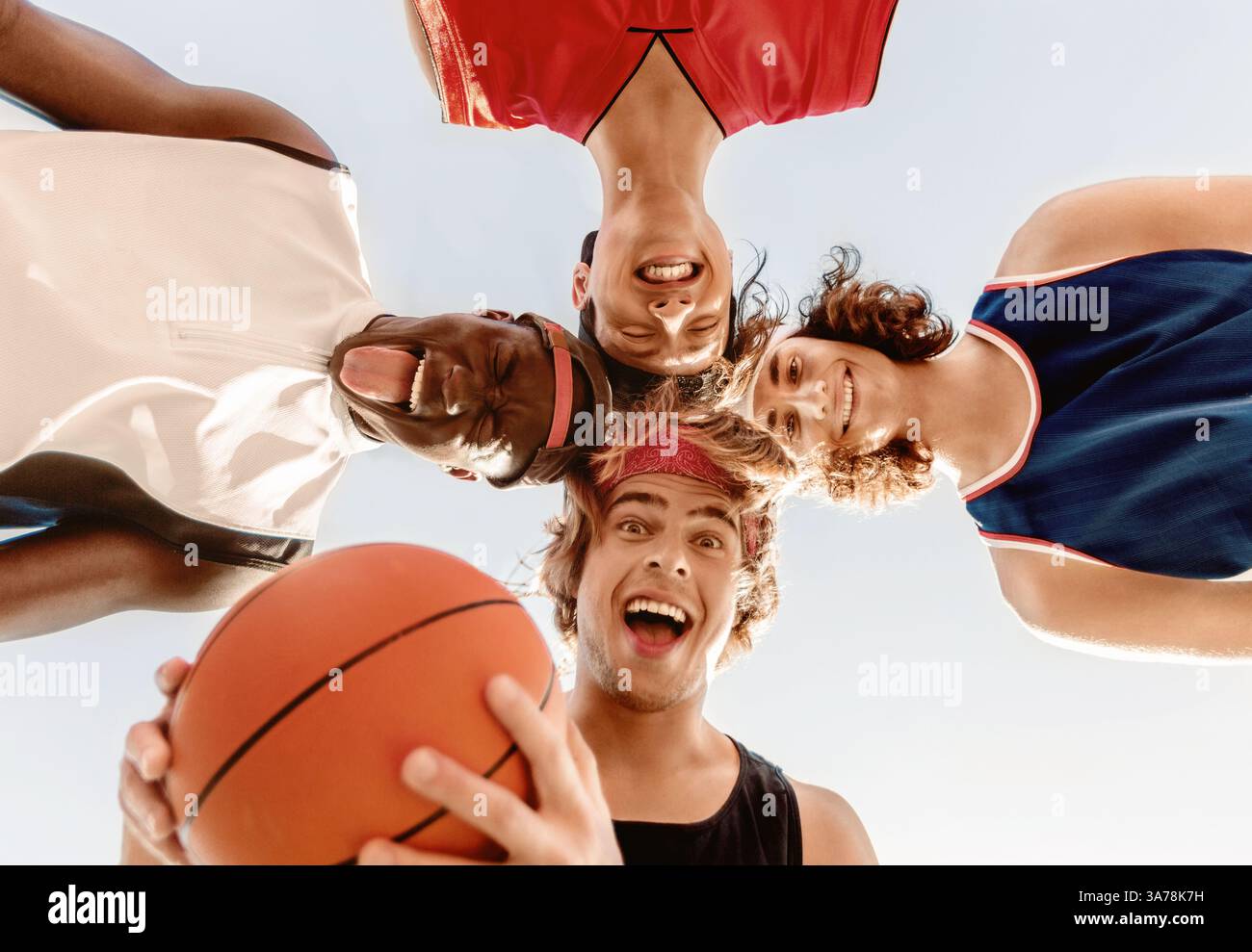 Diverse basketball players putting their heads together and making ...