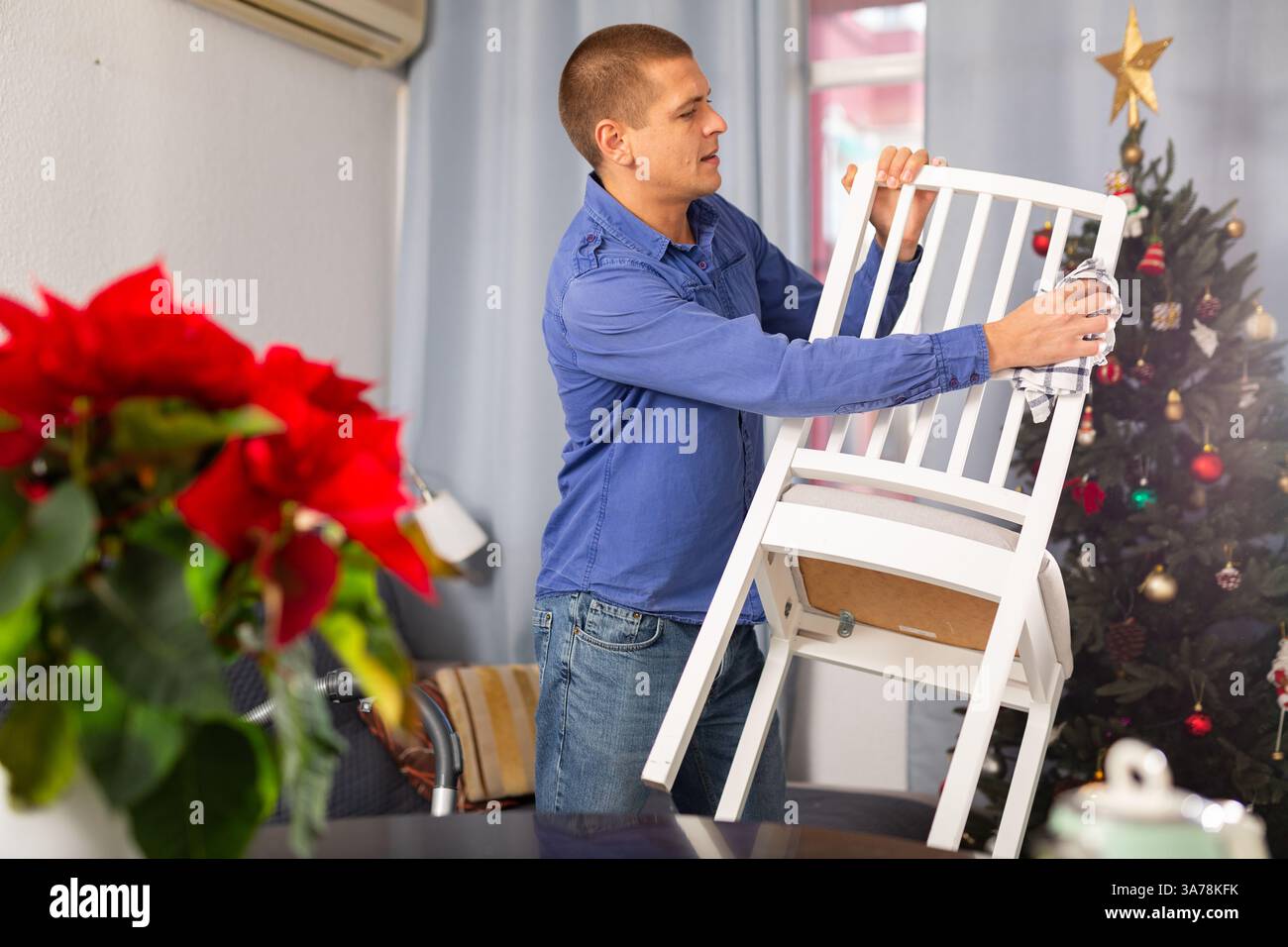 Man wiping dust from chair Stock Photo - Alamy