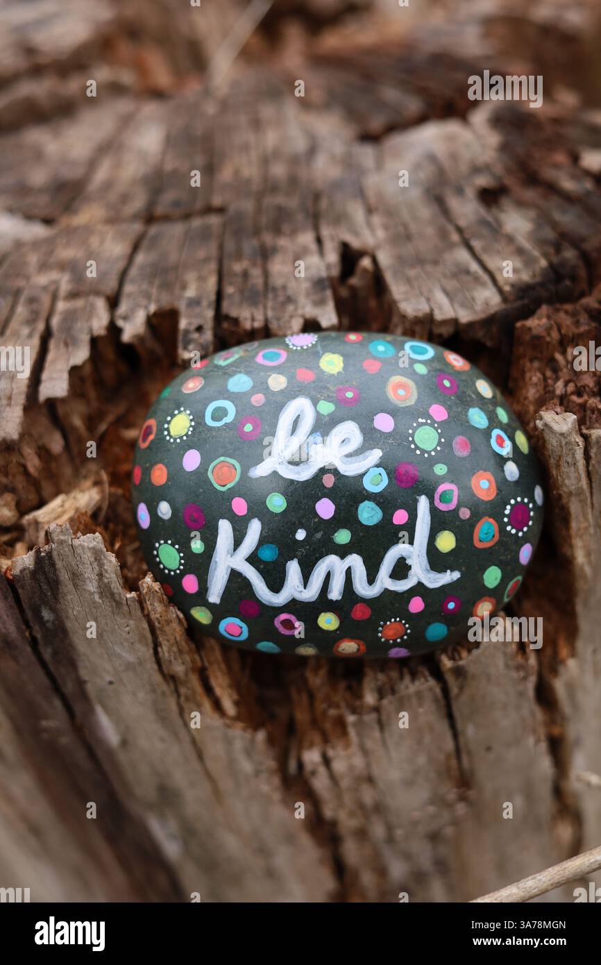 Fractured rotting wooden post with be kind kindness rock Stock Photo ...