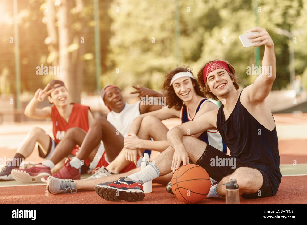 Group of basketball players taking selfie together after training at ...