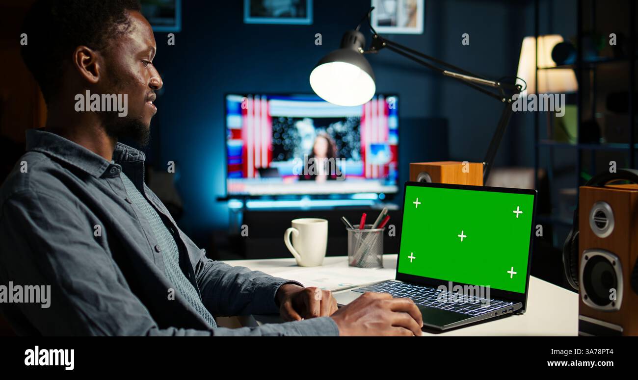 Teleworker at home editing documents next to mockup on his laptop, submitting reports and files ...
