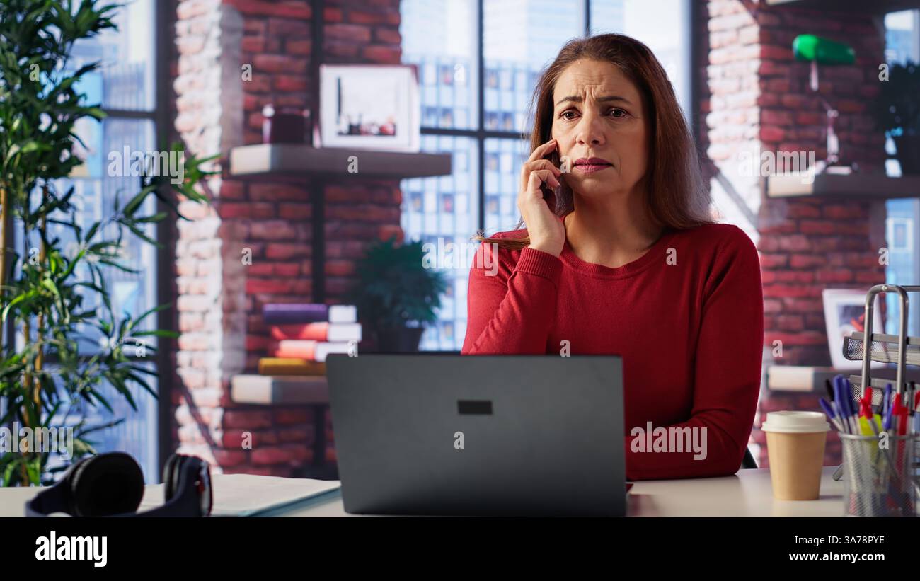 Mature woman getting angry and yelling on the phone call at the desk ...