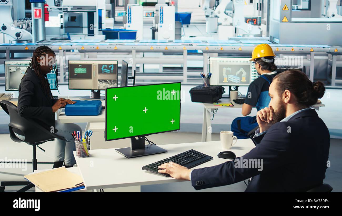 Photovoltaics factory worker monitors system performance on green screen PC. Solar panels ...