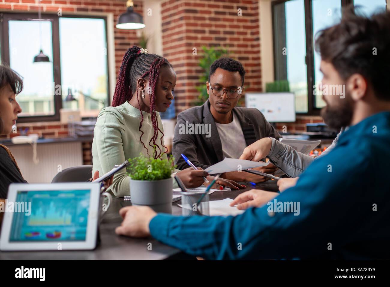 Diverse coworkers collaborate on project in modern workspace with ...