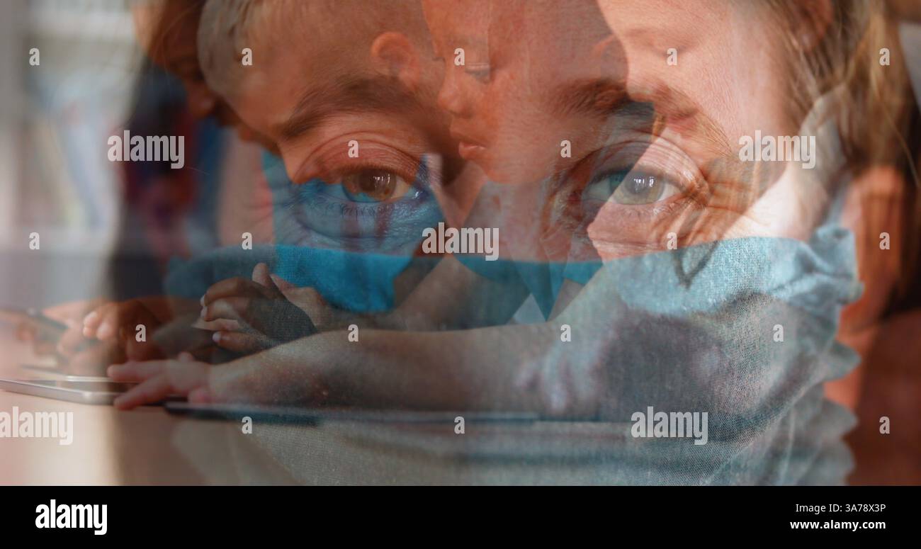 In school, woman wearing mask observing children playing with tablets ...