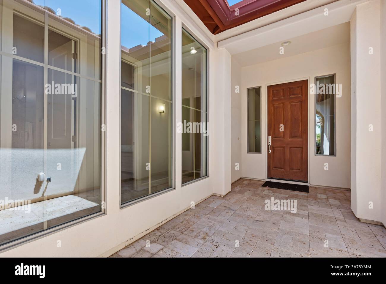 A lovely porch complete with a sturdy wooden door and many windows ...