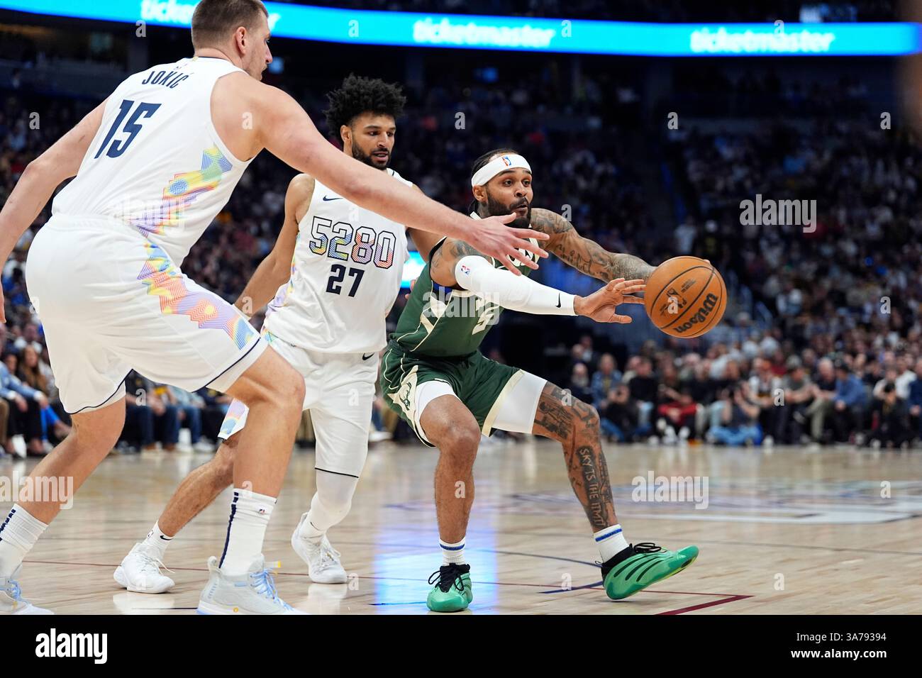 Milwaukee Bucks guard Gary Trent Jr., right, passes the ball as Denver ...