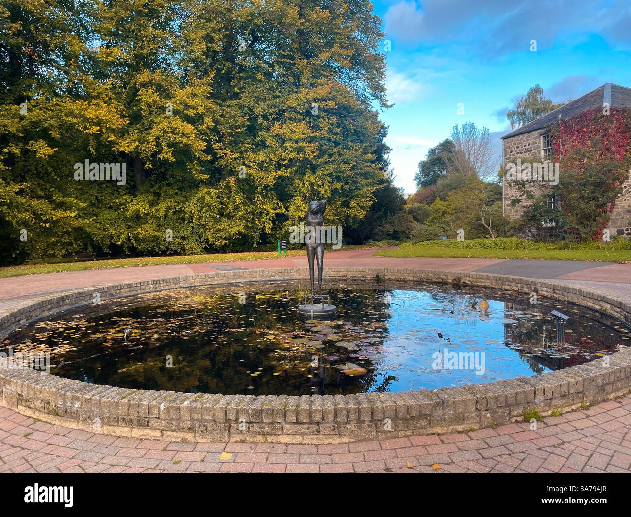 Reflective pond with bronze statue in a landscaped garden during autumn in Scotland Stock Photo ...