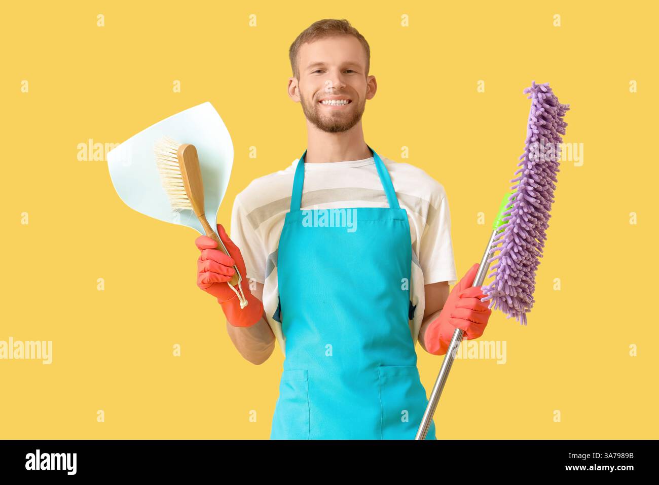 Male janitor with mop, dust pan and brush on yellow background Stock ...