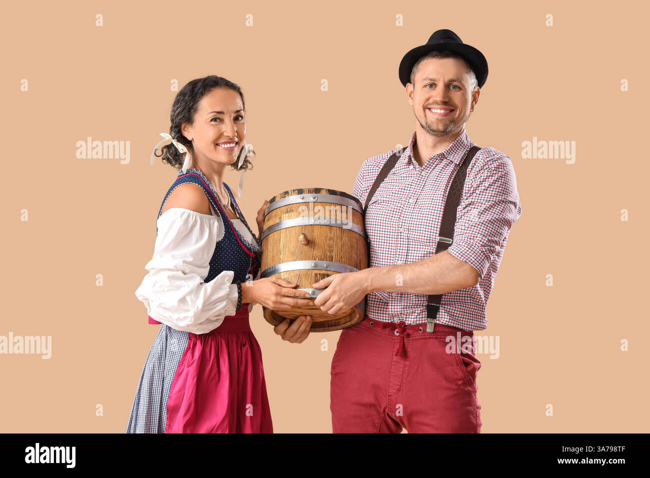 Happy mature waiters in traditional German clothes with barrel of beer ...