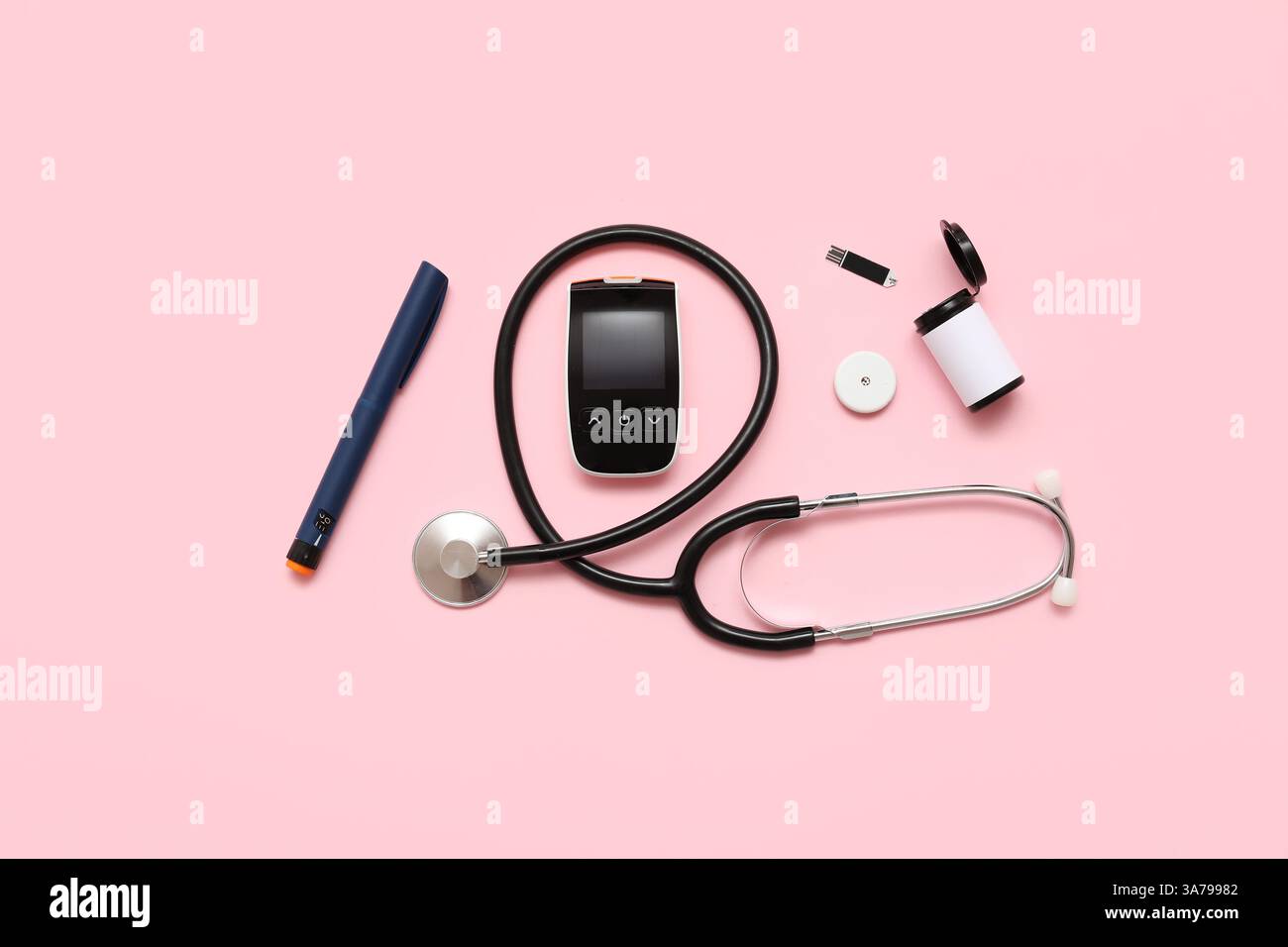 Glucometer with lancet pen, glucose sensor and stethoscope on pink ...