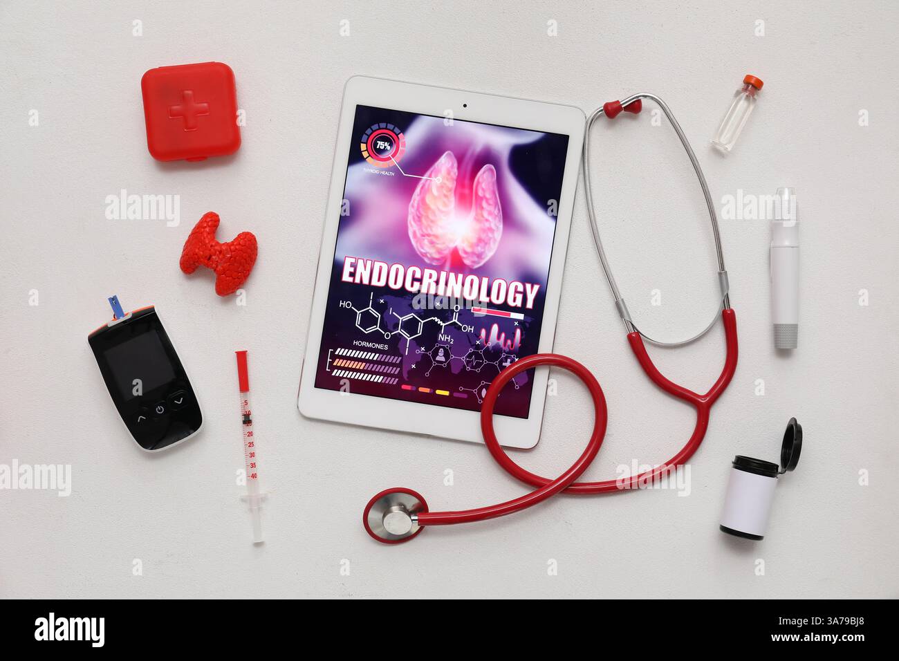 Tablet computer with thyroid gland model and medical supplies on light ...