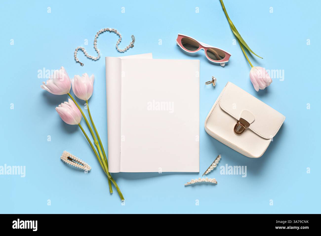 Blank fashion magazine with flowers, jewellery and sunglasses on blue ...