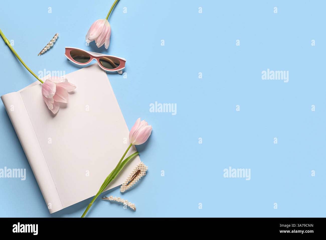 Blank fashion magazine with flowers, jewellery and sunglasses on blue ...