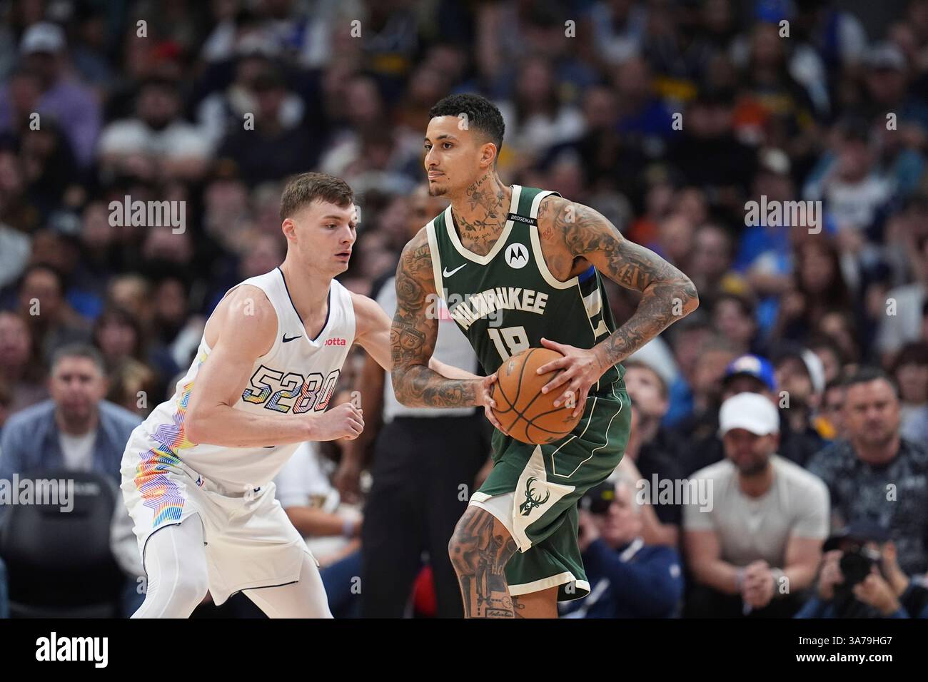Milwaukee Bucks forward Kyle Kuzma, right, looks to pass the ball as ...