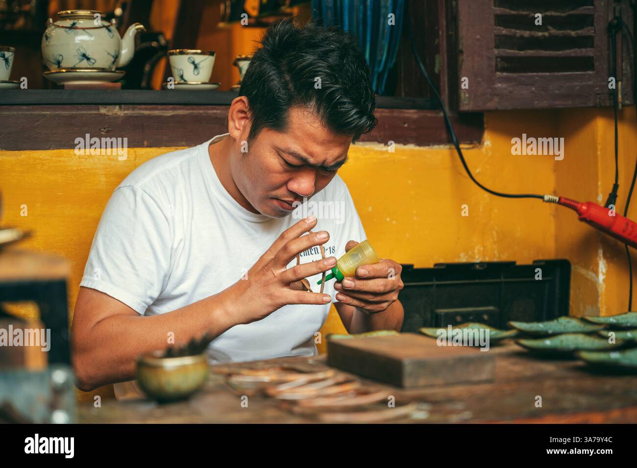 Vietnamese Asian man artisan craftsman works in a jewelry workshop on ...