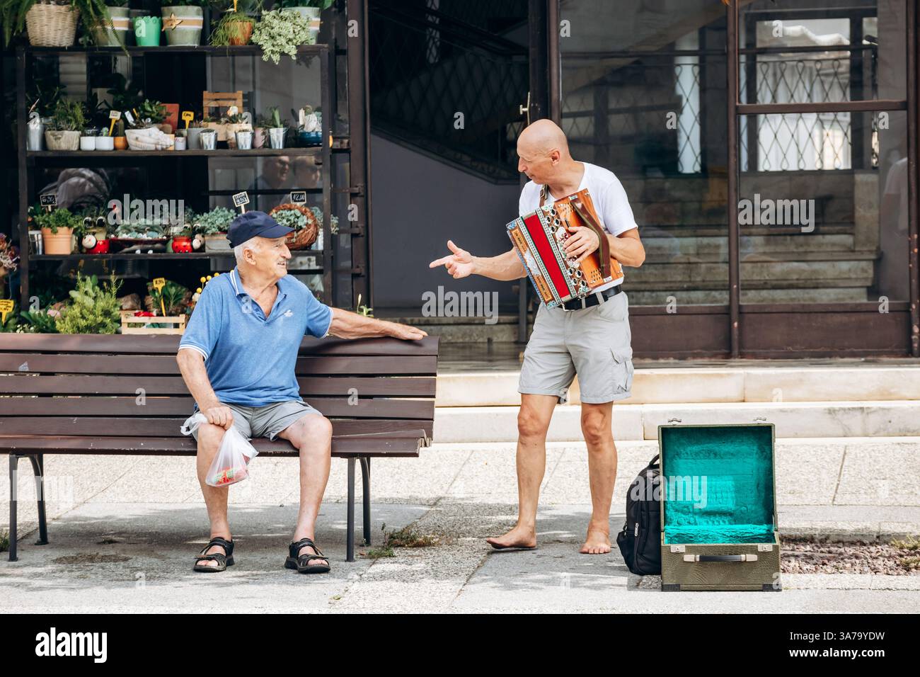 Koper, Slovenia - August 16, 2024: Two people having a conversation at ...