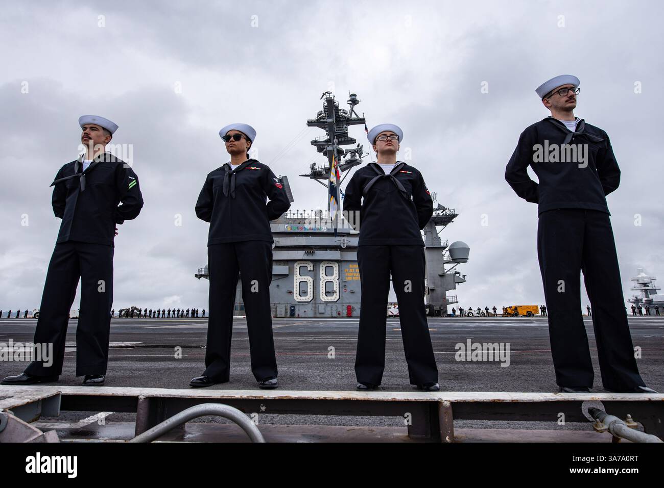 Sailors man the rails on the flight deck of the aircraft carrier USS ...