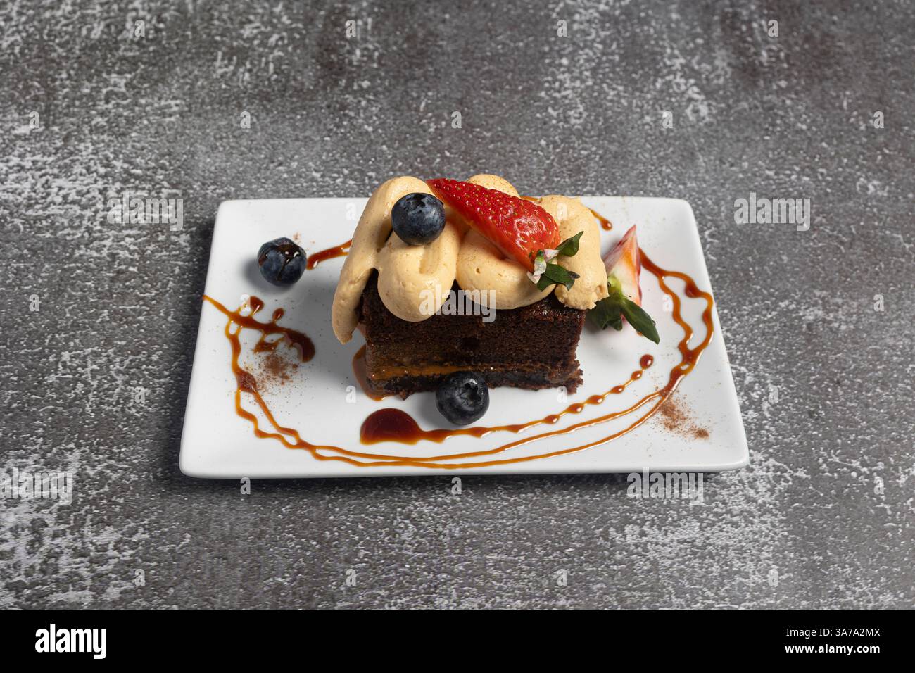 Chocolate cake slice is garnished with dulce de leche cream, fresh ...