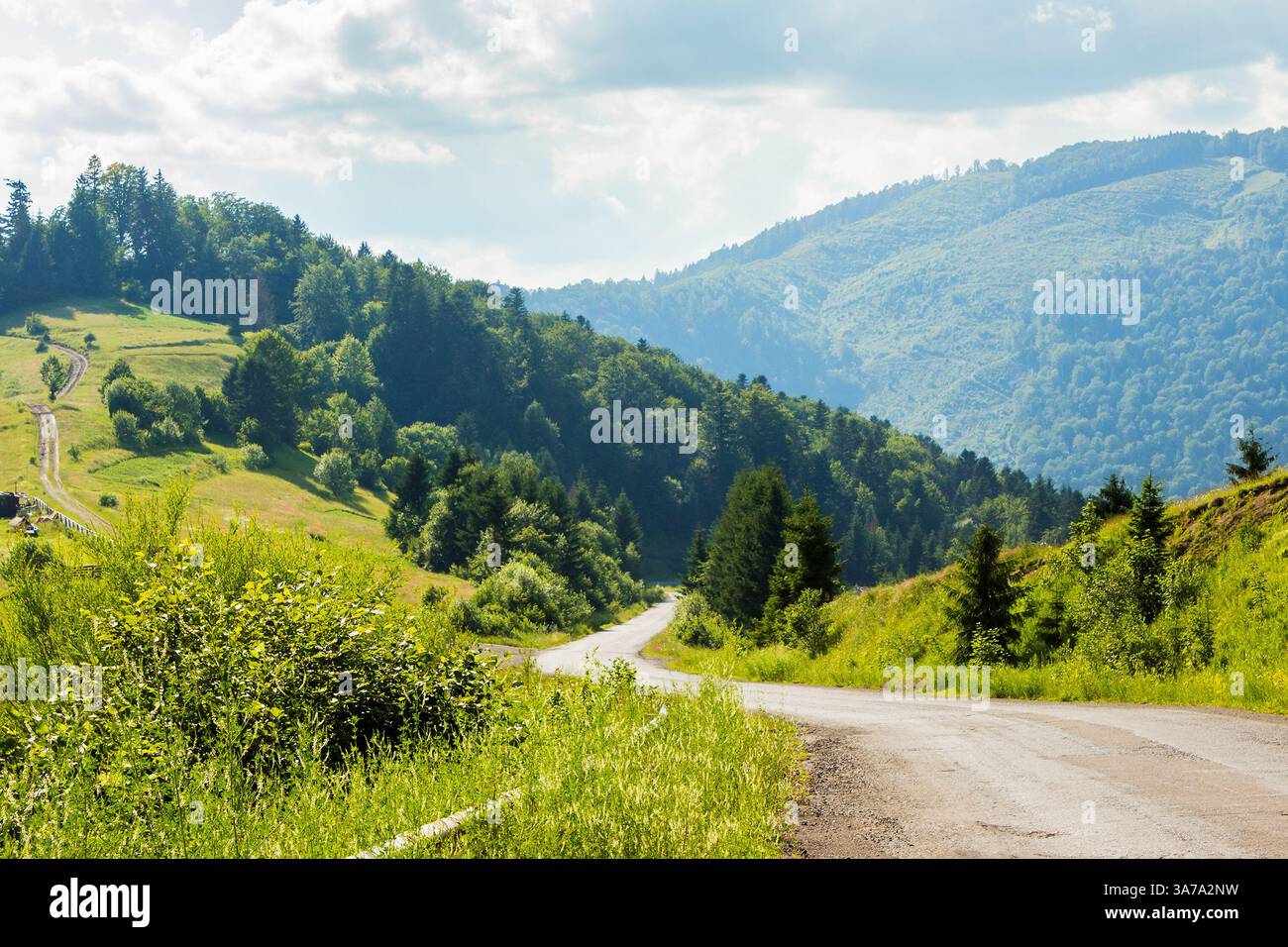 old country road winding through mountainous countryside. rural scenery. wonderful summer ...