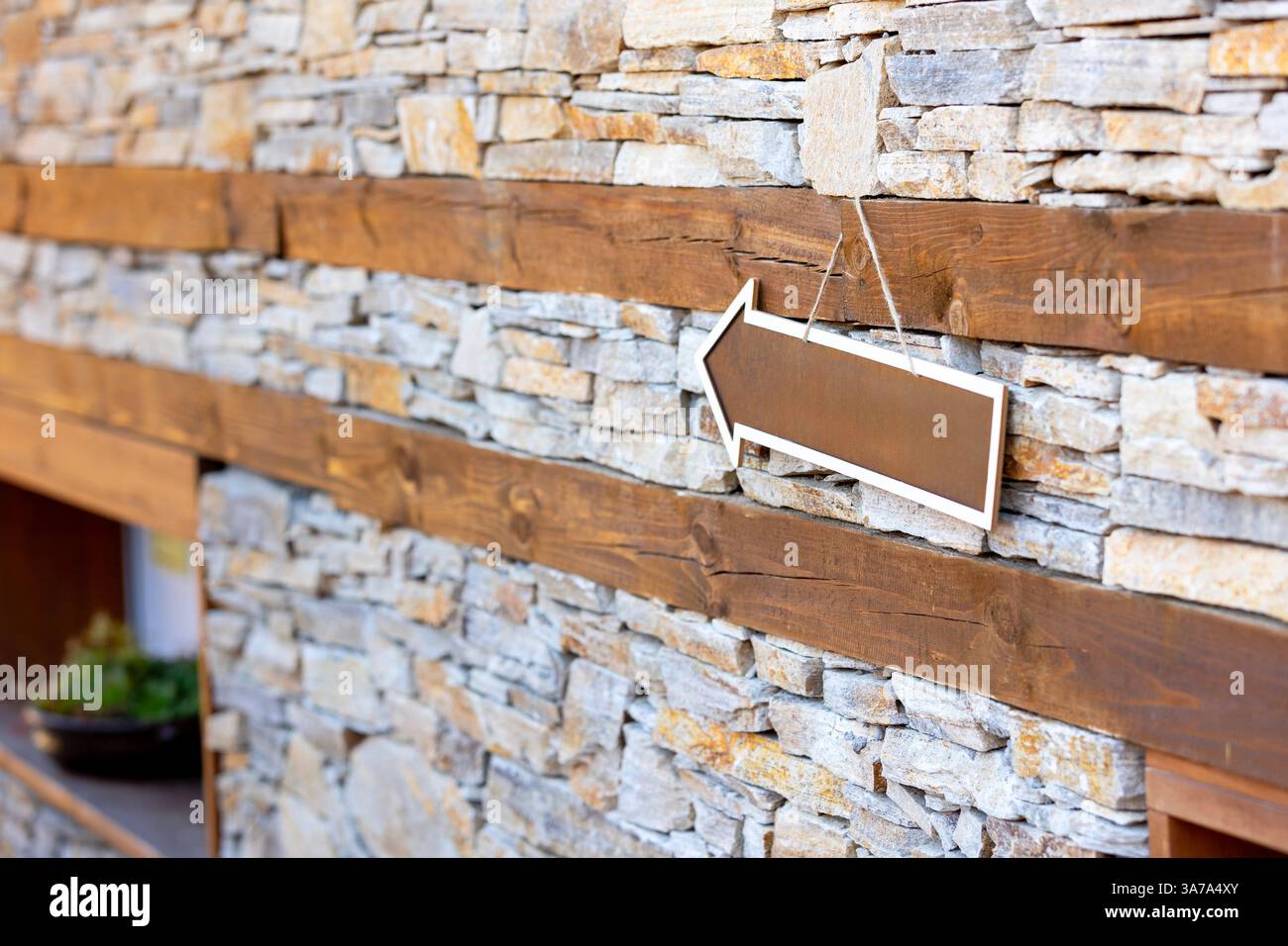 directional arrow sign against textured historical stone wall ...