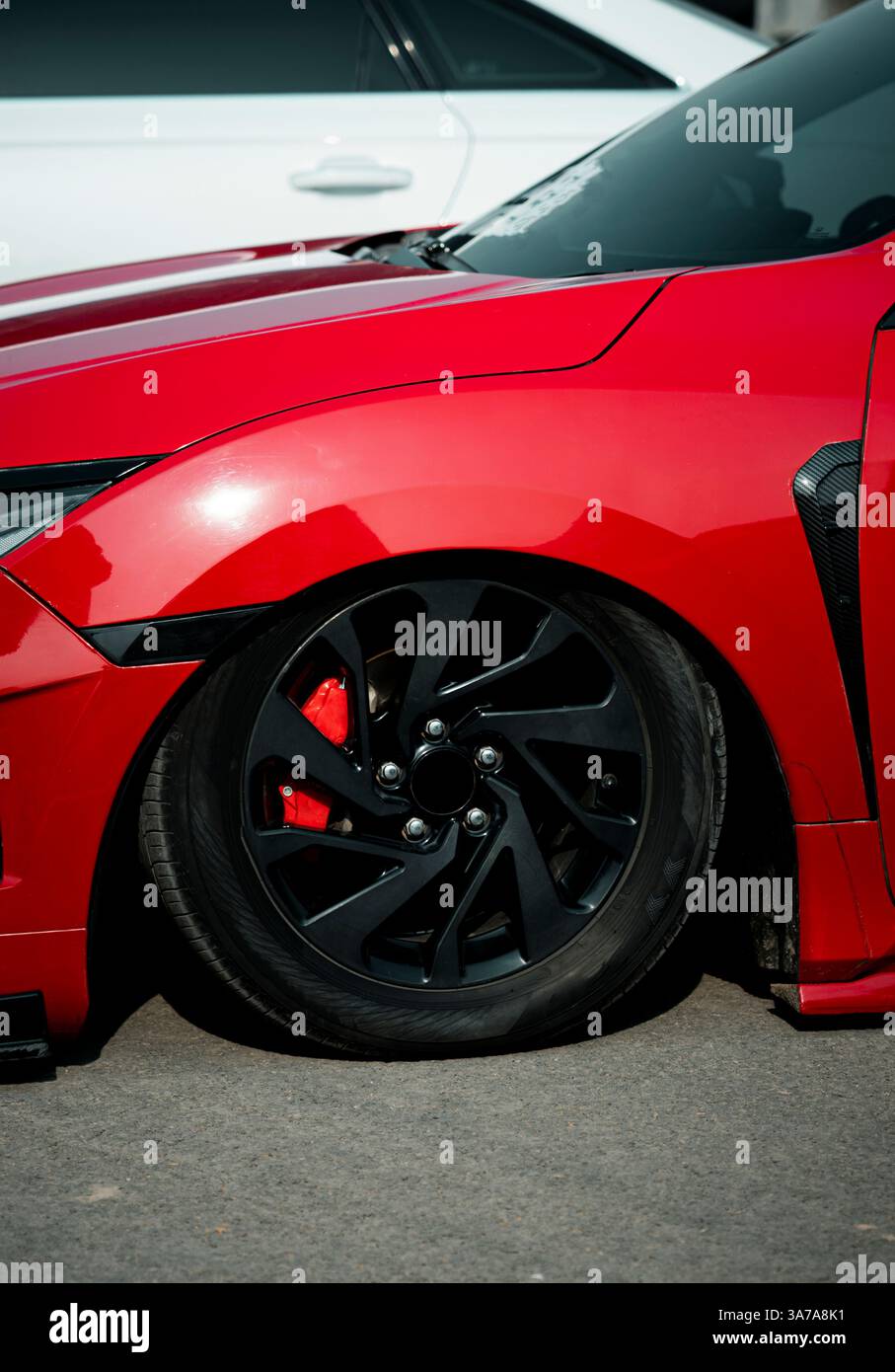 A sleek red sports car wheel with a premium alloy rim, highlighting ...
