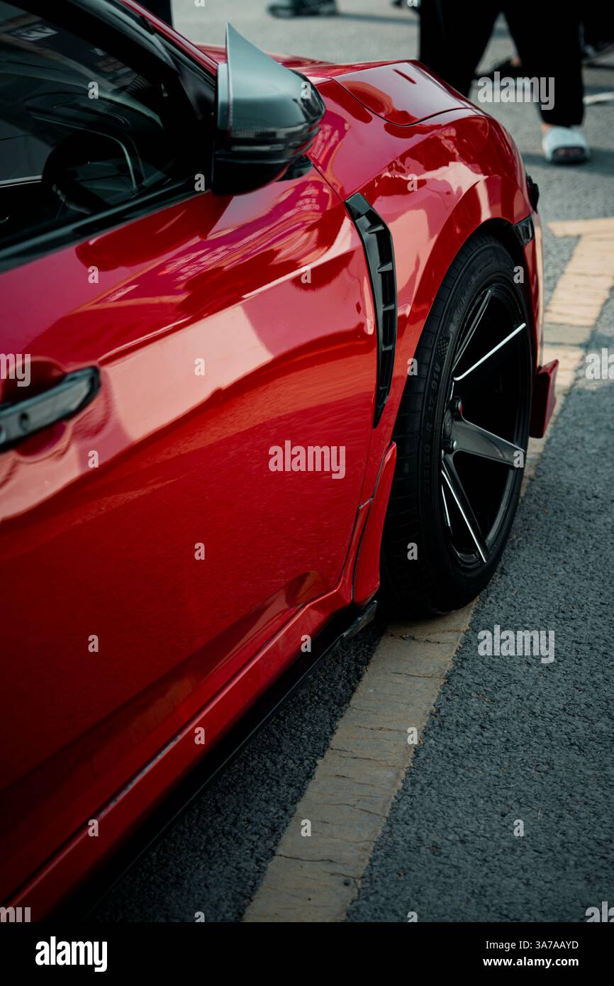 A striking side-profile shot of a red sports car, showcasing its sleek ...