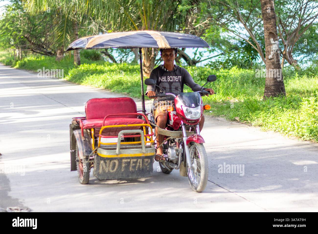 A tricycle locally known as payong-payong plying the road in Mindanao ...