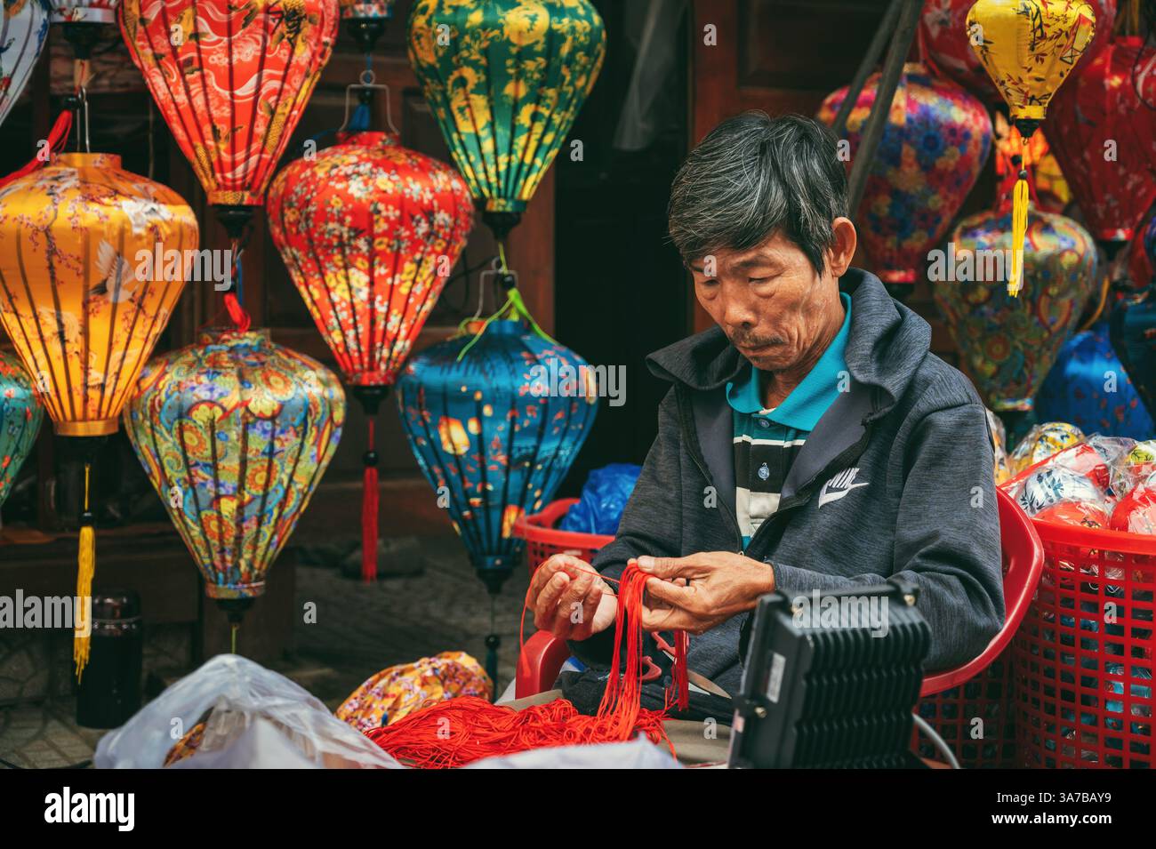 Asian man artisan craftsman makes Vietnamese silk lanterns at ancient ...