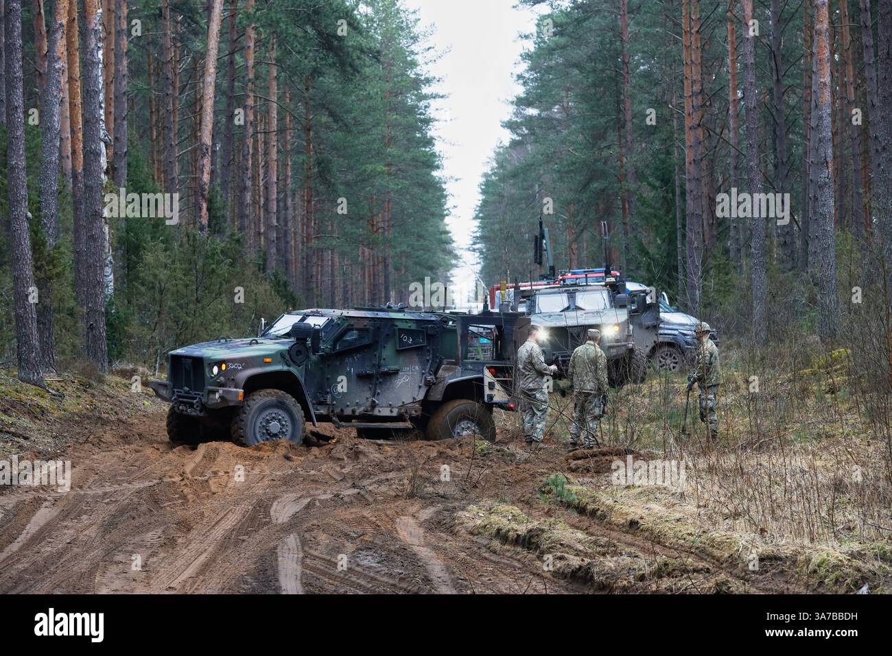 U.S. soldiers stand near military vehicles parked at a training range ...