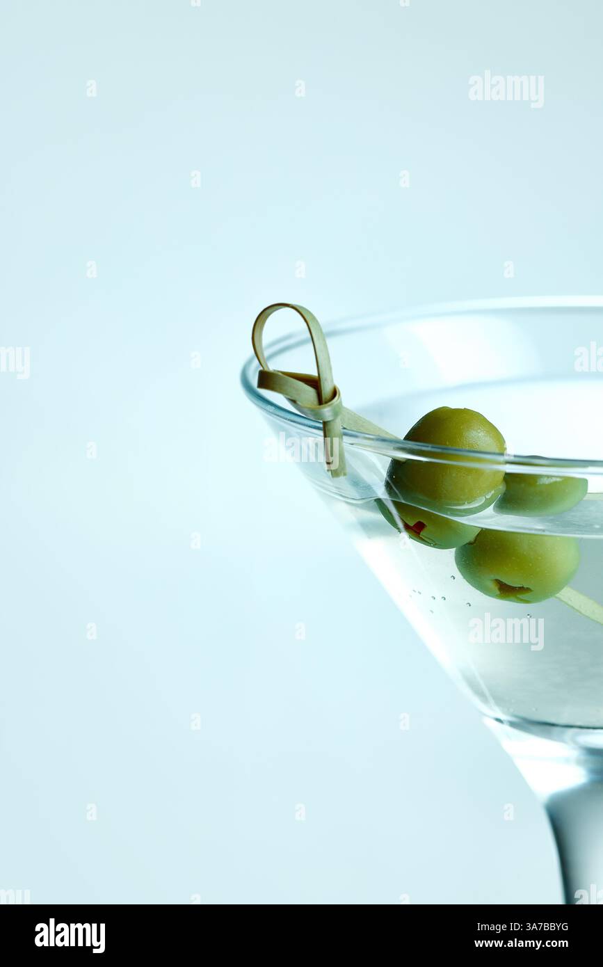 Minimalist close-up of Martini with olives on light background ...