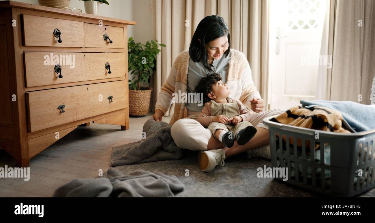 Home, baby and mother fold laundry on bedroom floor for domestic chores ...