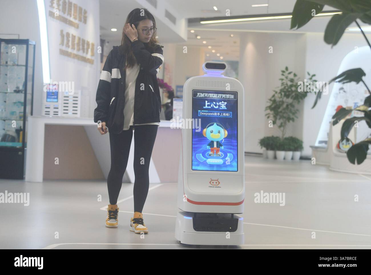 HANGZHOU, CHINA - MARCH 27, 2025 - A citizen follows an intelligent ...