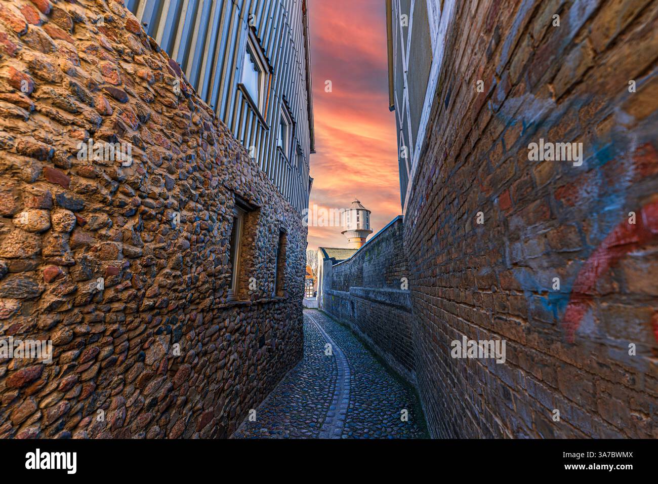 Narrow Alley with a View to the Water Tower at Sunset, Nauen, Germany ...