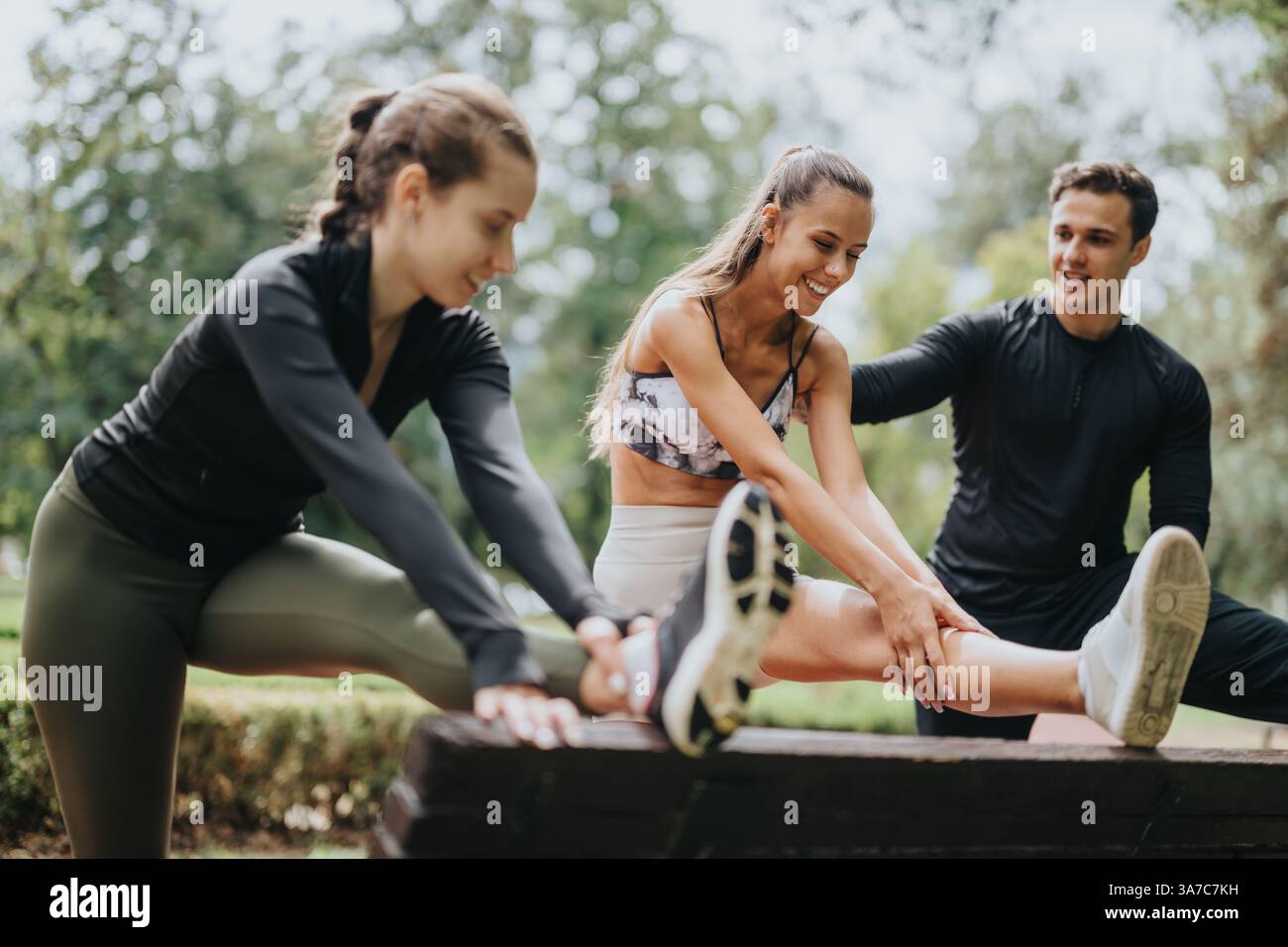 Group of friends doing stretching exercises together in an outdoor park ...