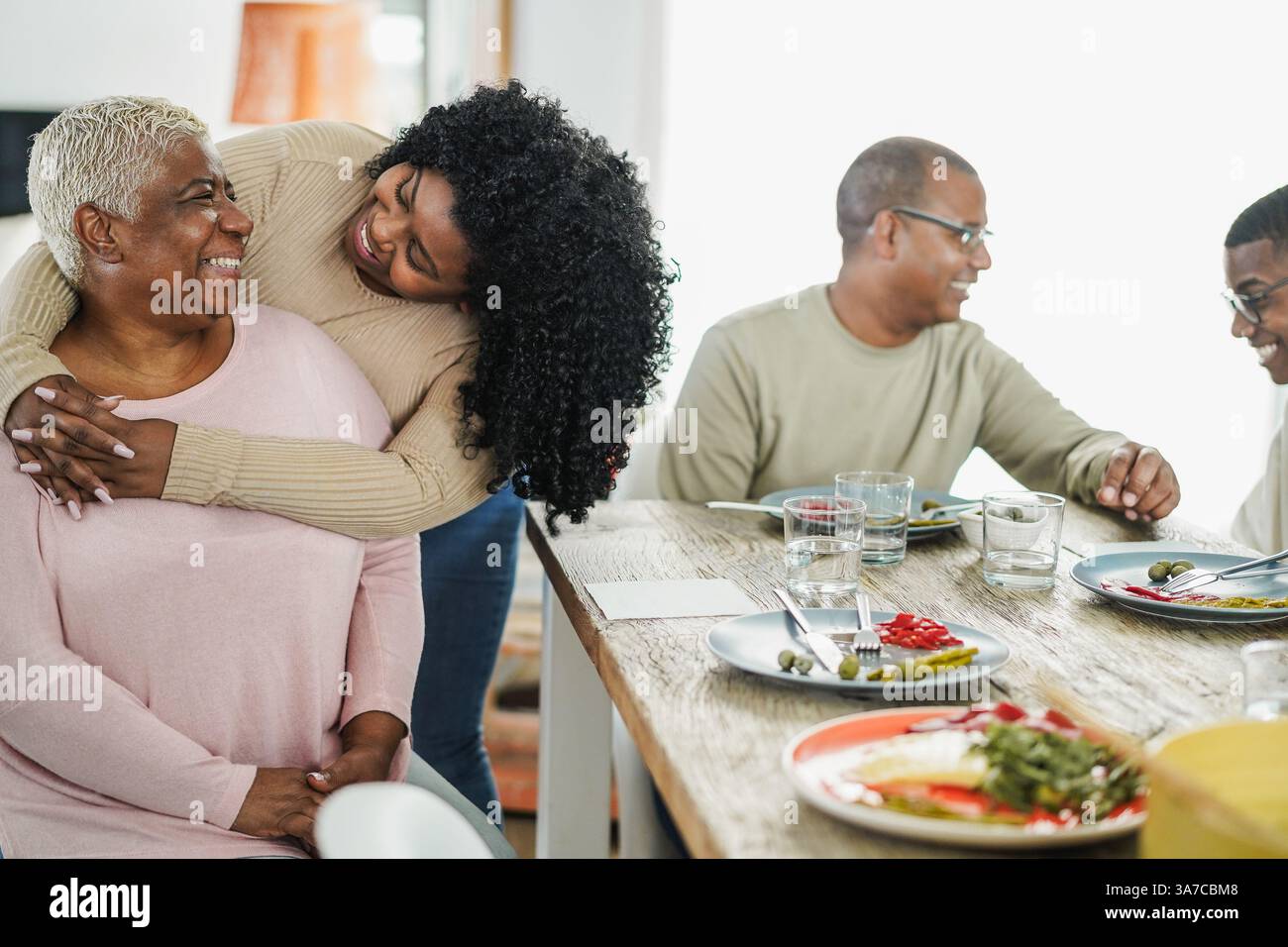 African american daughter hugging her mother indoor at home - Mom day ...