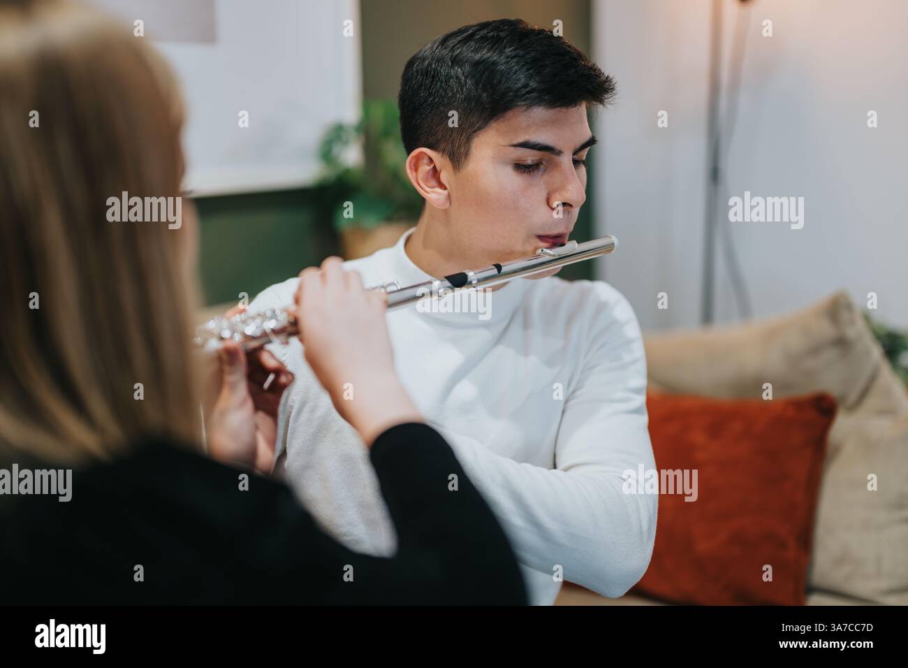 Man playing the flute in a cozy indoor setting with a teacher Stock ...