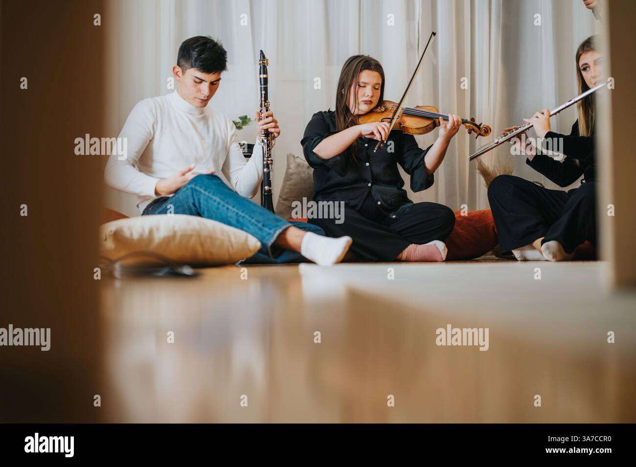 A group of friends playing musical instruments together in a cozy ...