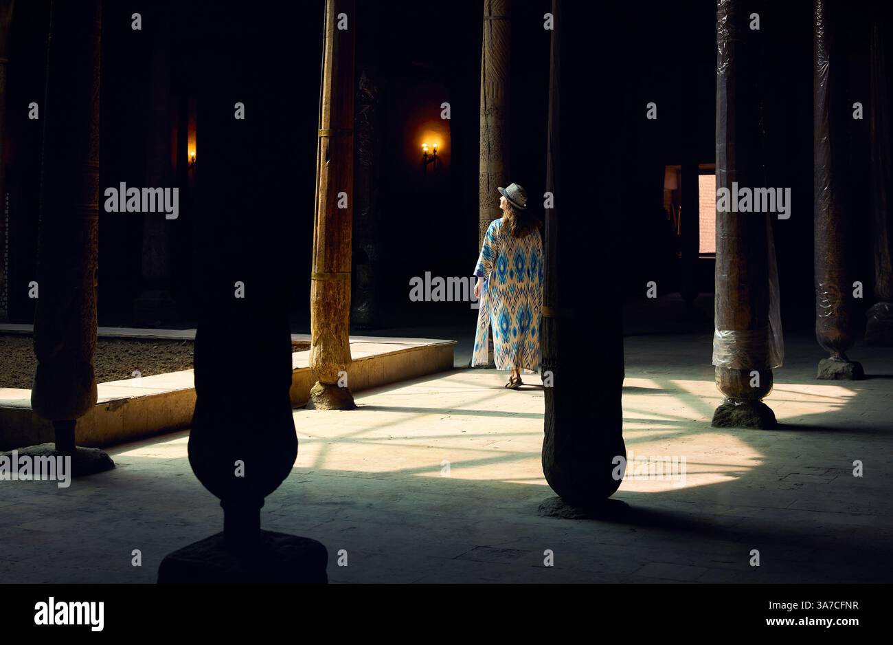 Woman tourist in ethnic dress at old hall with wooden column of Juma ...