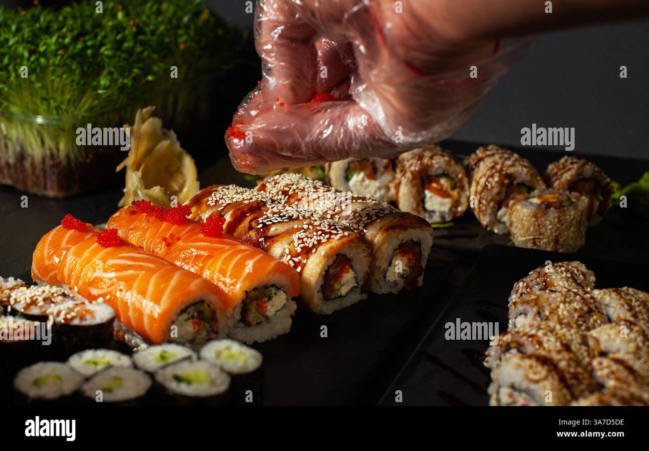 sushi rolls of various types that the cook sprinkles with sesame seeds ...
