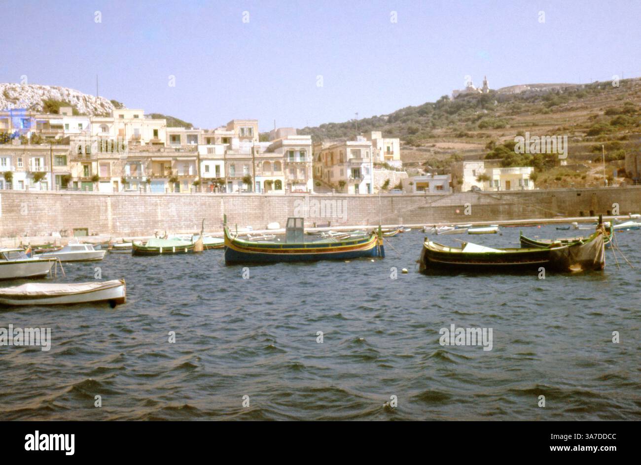 Traditional Maltese fishing boats, known as luzzus, float in the waters ...