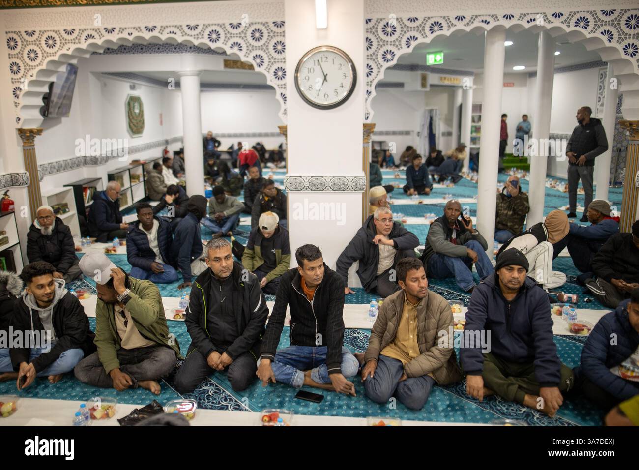 Madrid, Spain. 26th Mar, 2025. A group of men share Iftar, the meal ...