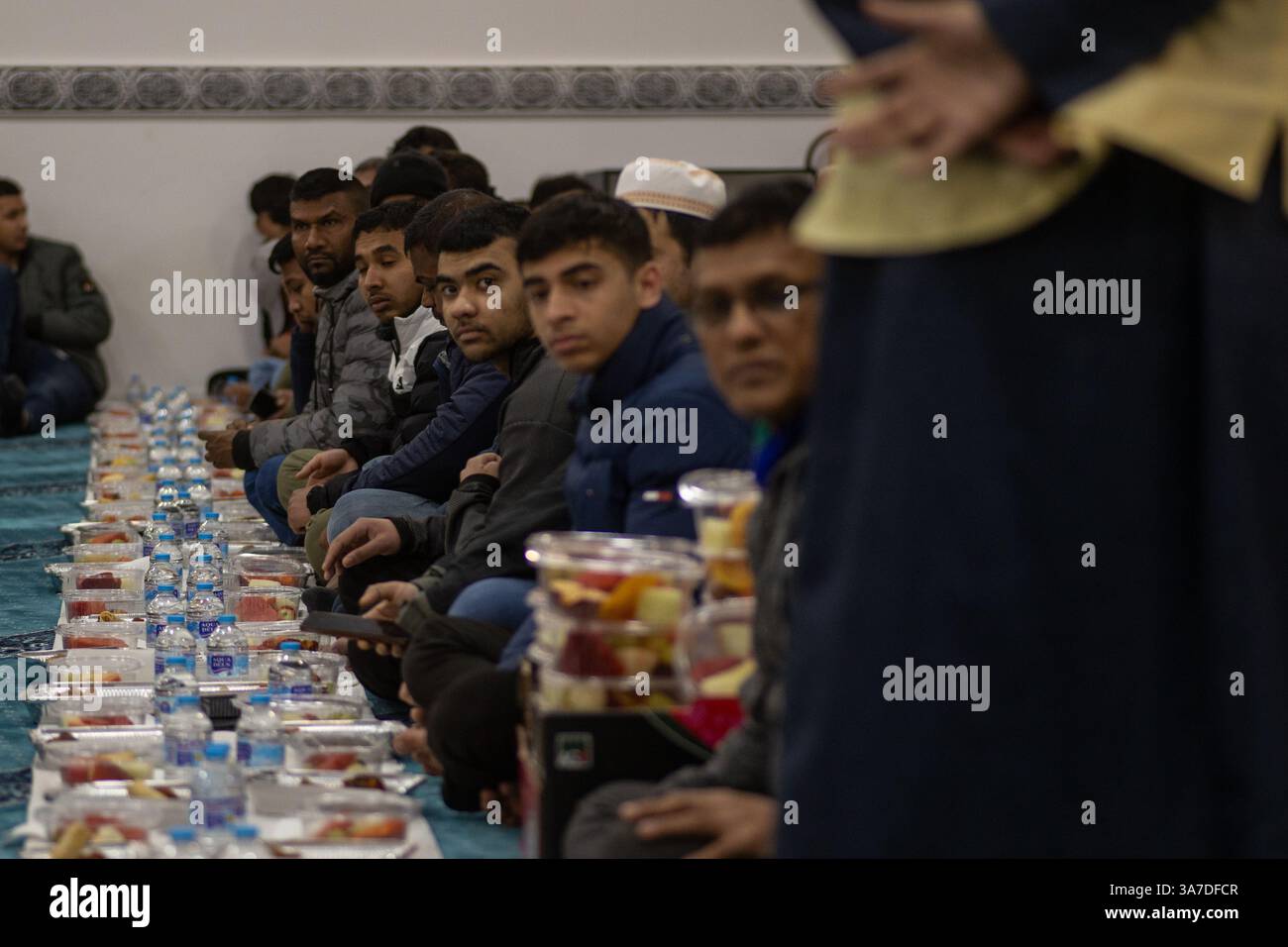 Madrid, Spain. 26th Mar, 2025. A group of men share Iftar, the meal ...