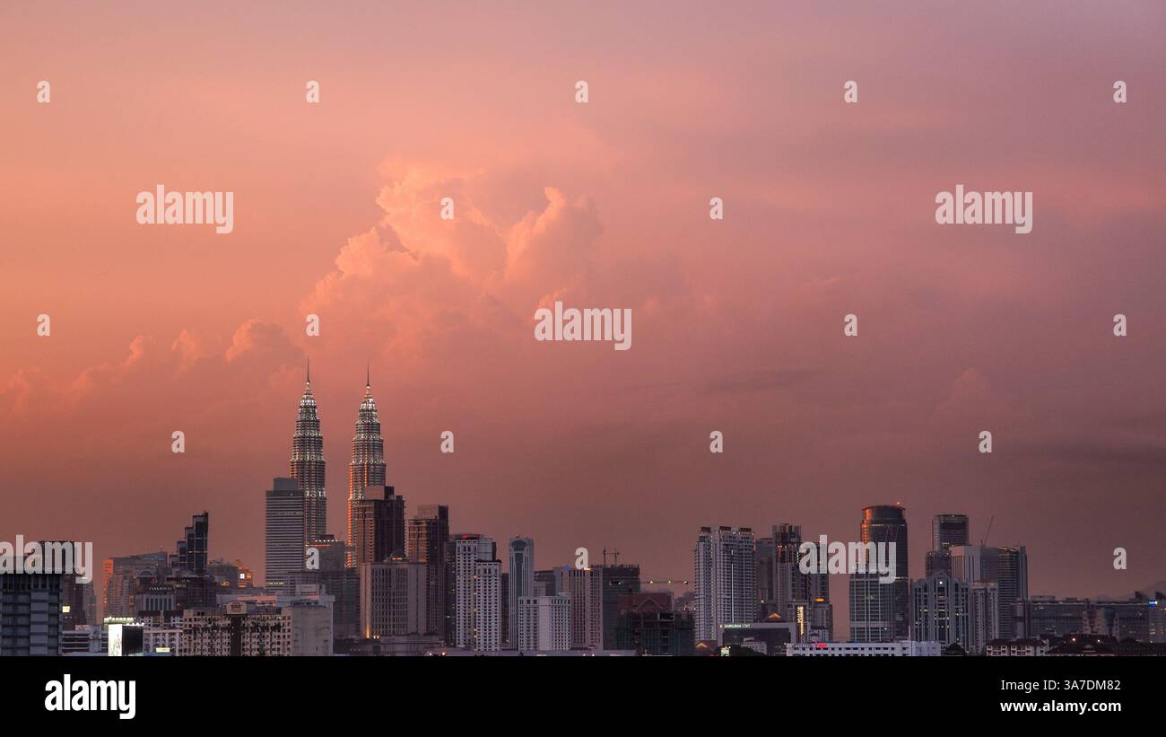 Petronas Twin Towers during golden hour just before sunset with pink red hues Stock Photo - Alamy